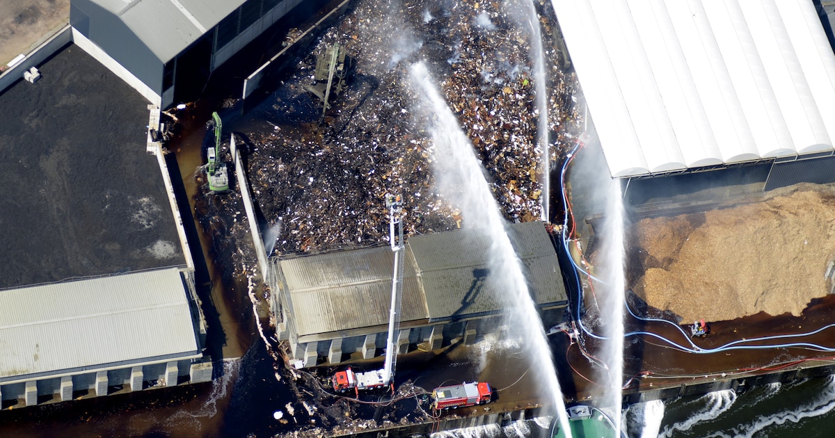 KIJK. Luchtbeeld toont bluswerken bij smeulende berg houtschilfers in ...