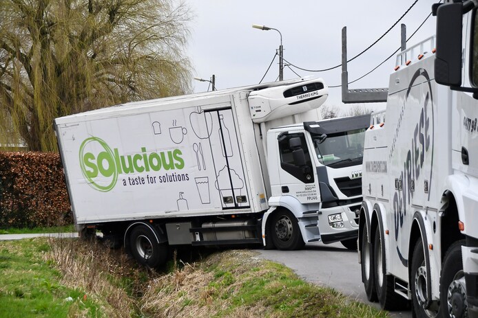 Vrachtwagen raakt vast met achterwielen in gracht: grote hijskraan ...