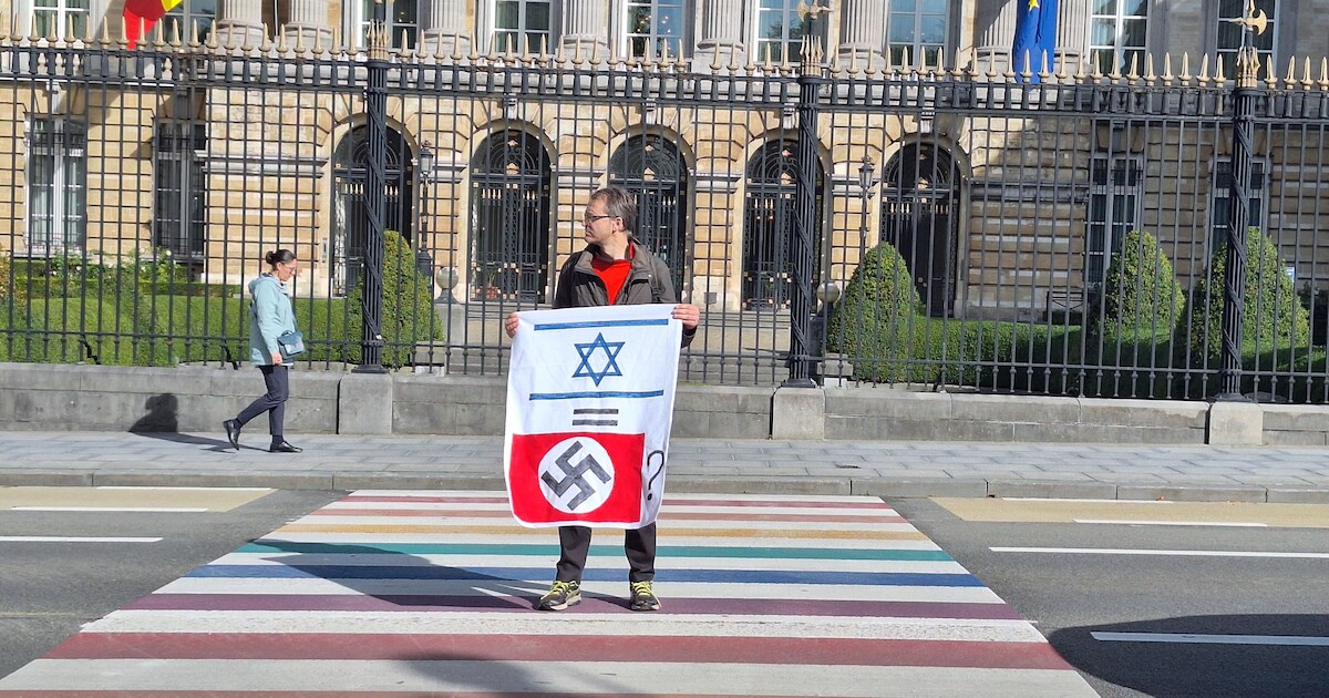 Activist Wouter Mouton staat met opvallende vlag aan federaal parlement ...